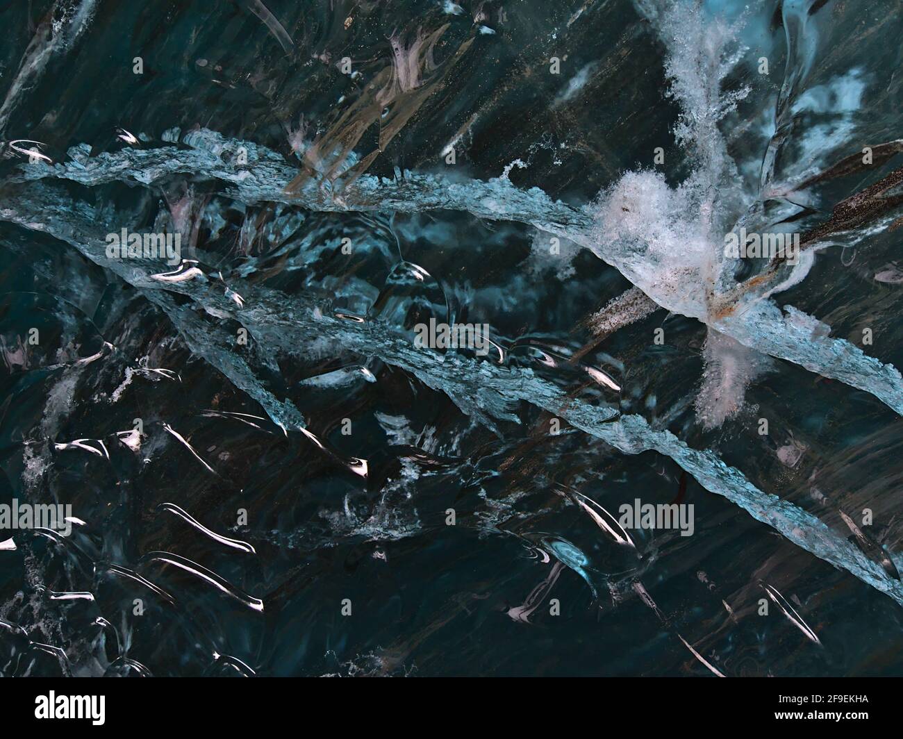 Closeup view of the clear, blue shimmering ice surface on the wall of ...