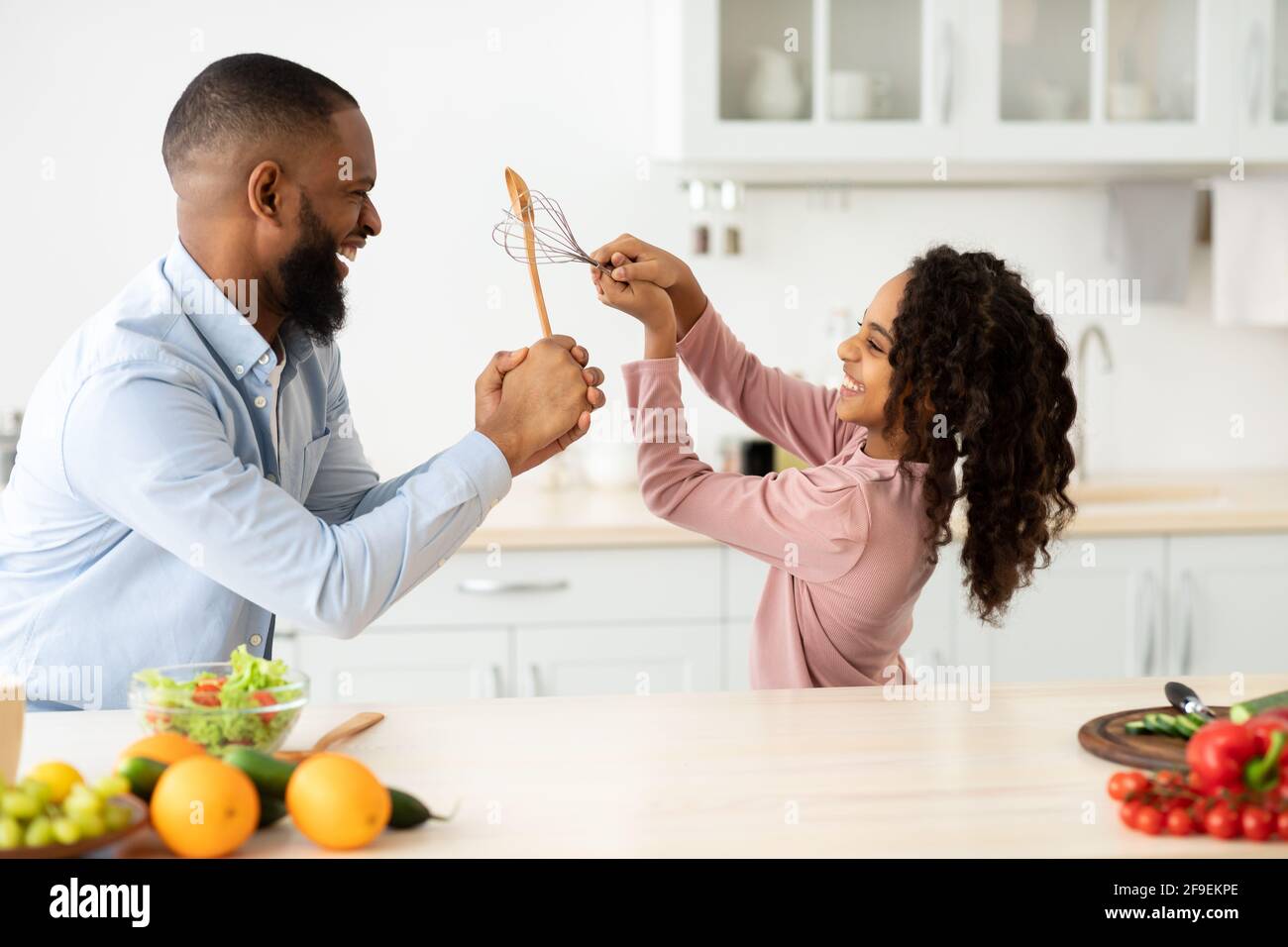 Black father and daughter having silly fight in the kitchen Stock Photo ...