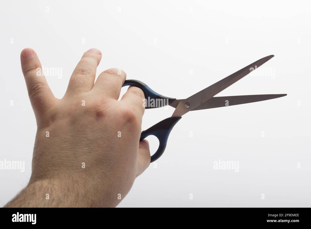 Scissors in the hands of a man. Stationery scissors in hand isolated on ...