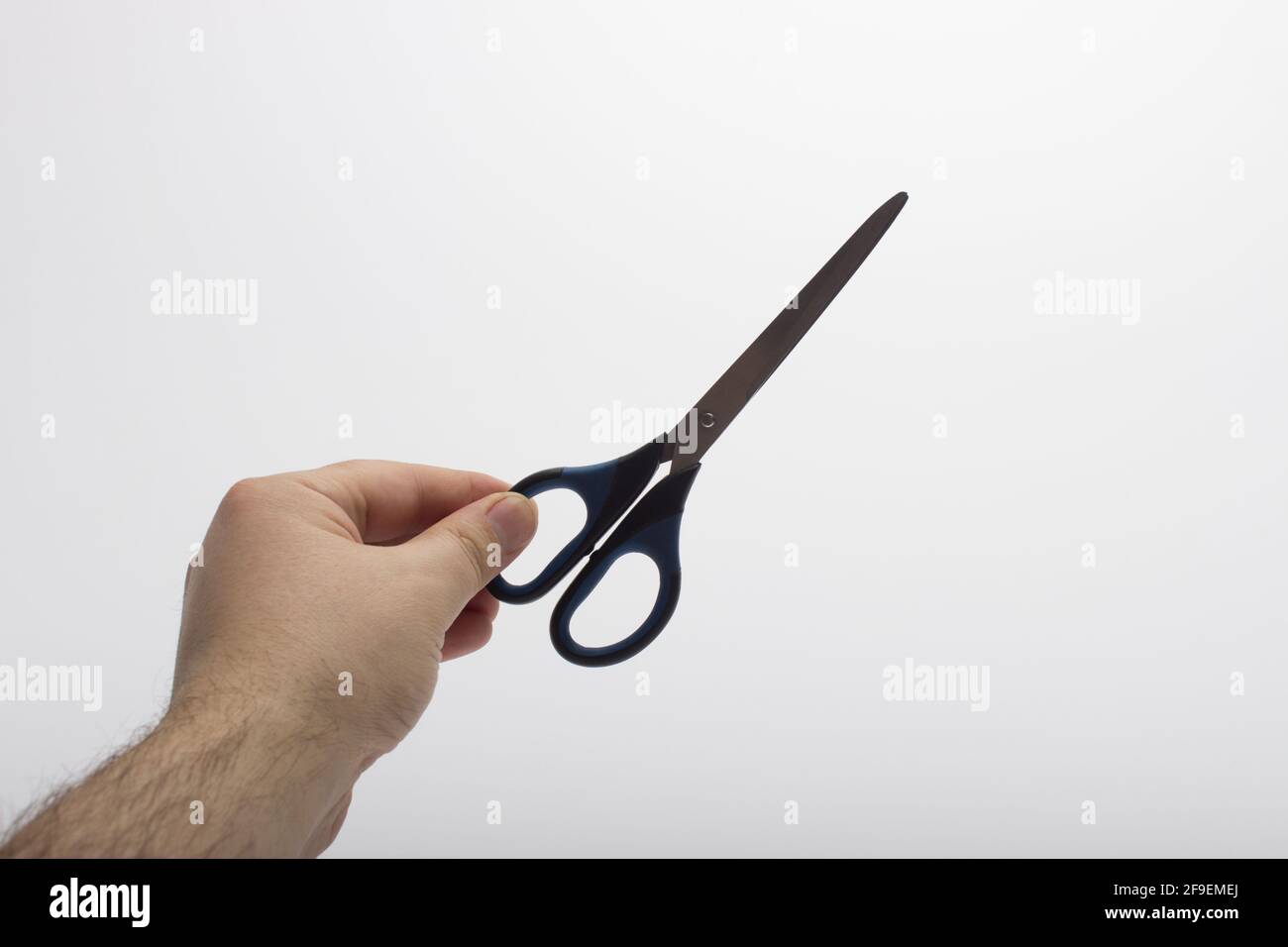 Hand is holding a scissors isolated on a white background. Stationery ...