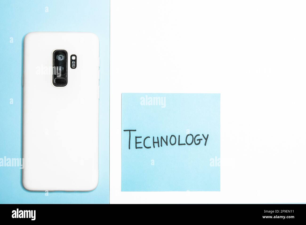 A closeup of a modern smartphone with a "TECHNOLOGY" note on a white ...