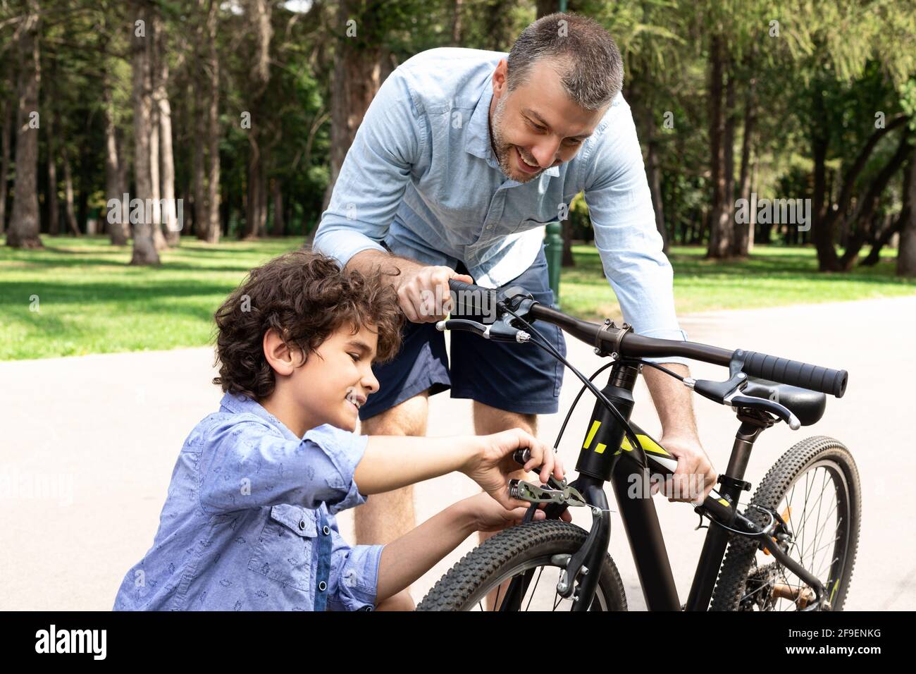 Closeup portrait of cheerful dad and son fixing bike Stock Photo - Alamy