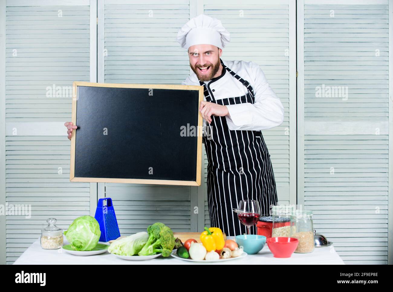 Learning to cook vegetables. Man holding empty blackboard. Chief cook ...