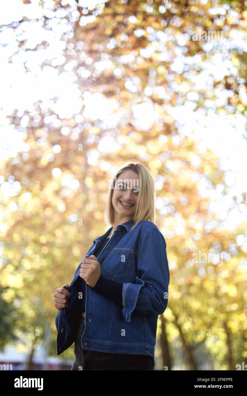 A low angle shot of a confident blonde smiling attractive girl in ...