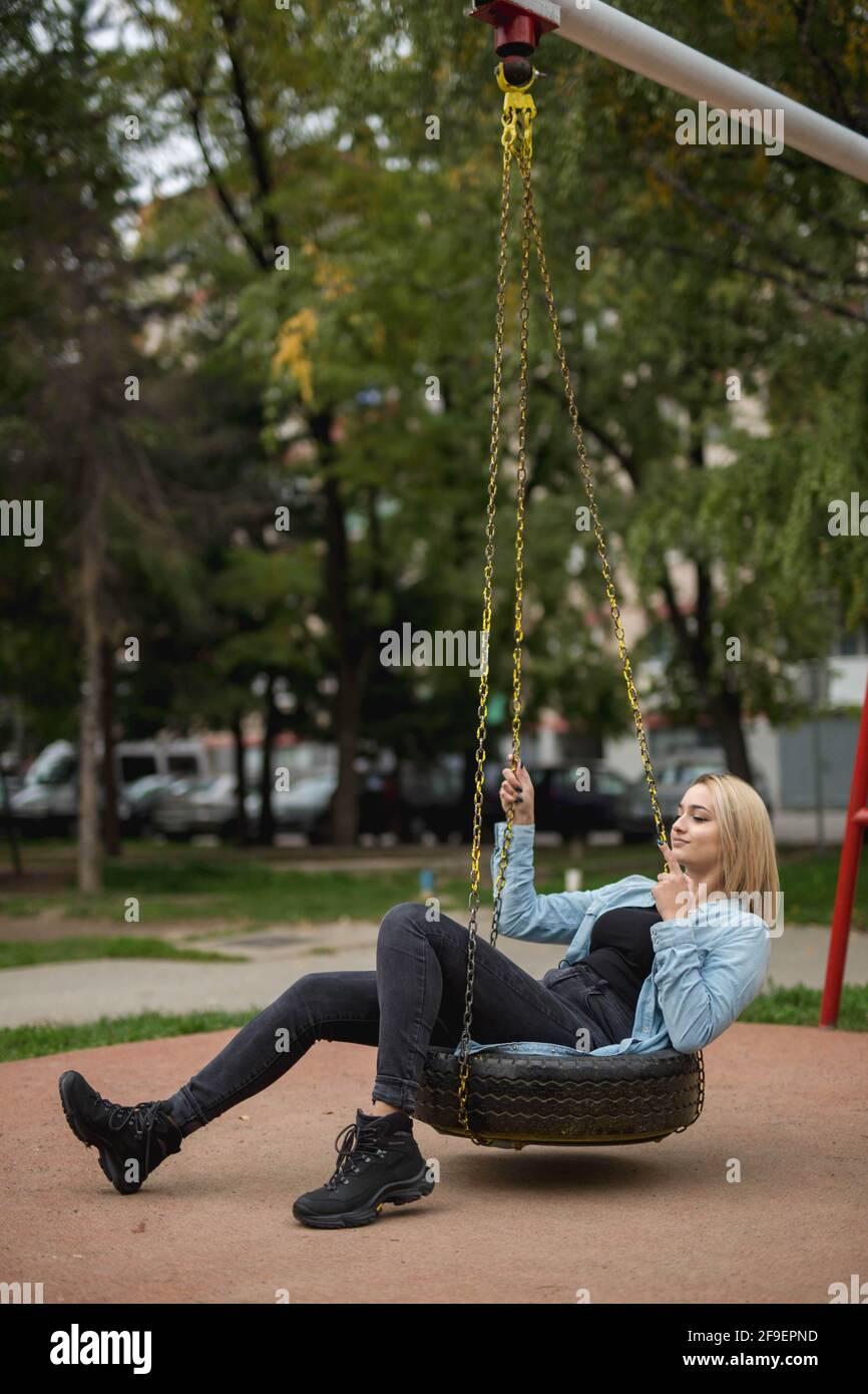 A vertical shot of a blonde cute elegant attractive woman having fun on ...