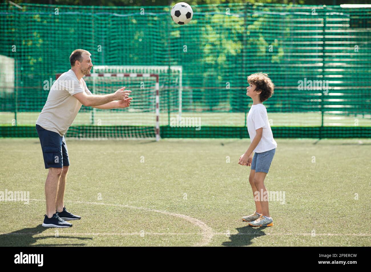 Sportive dad playing soccer with his son Stock Photo - Alamy