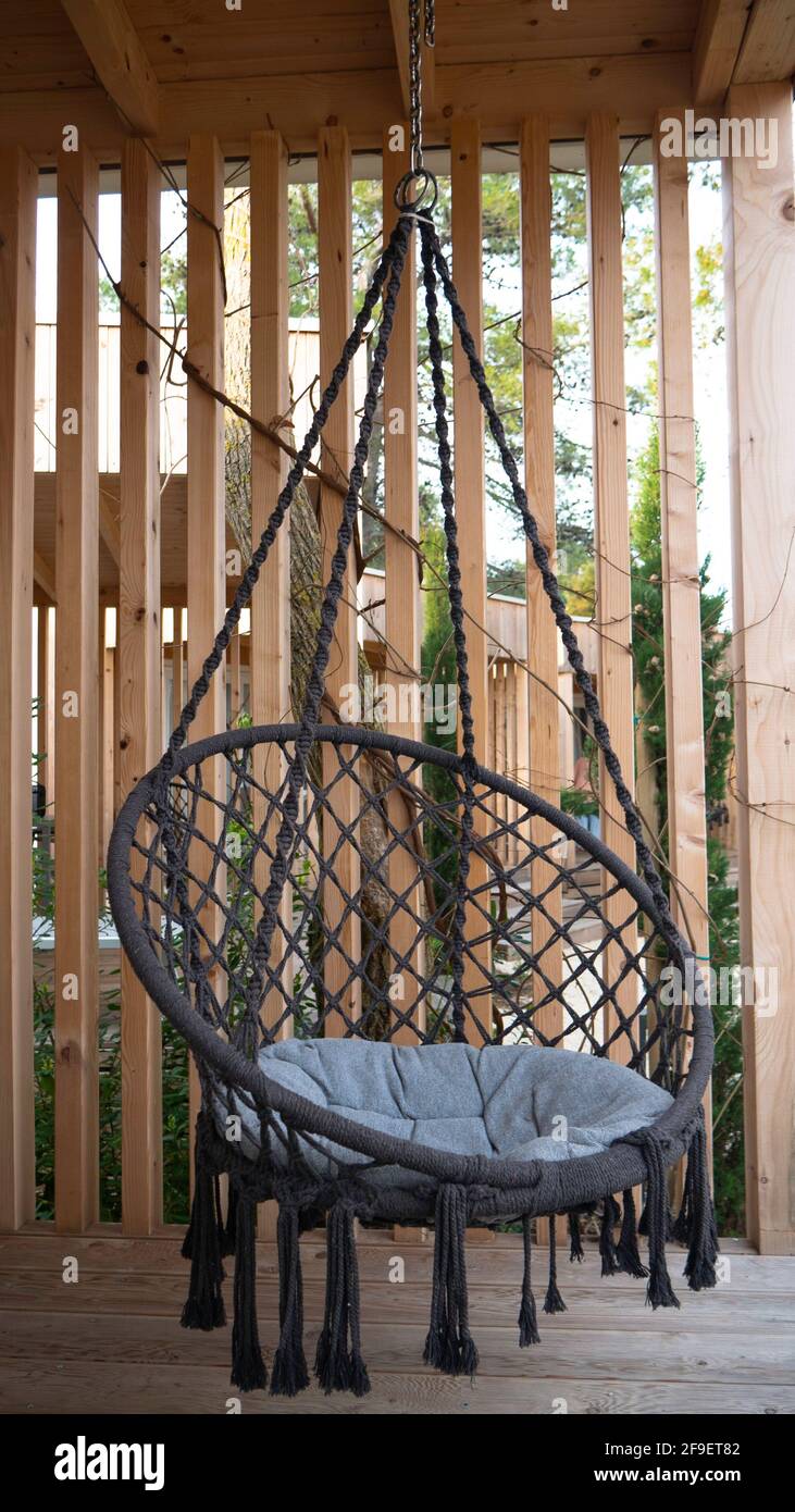 Hanging rope chair in a wooden patio Stock Photo - Alamy