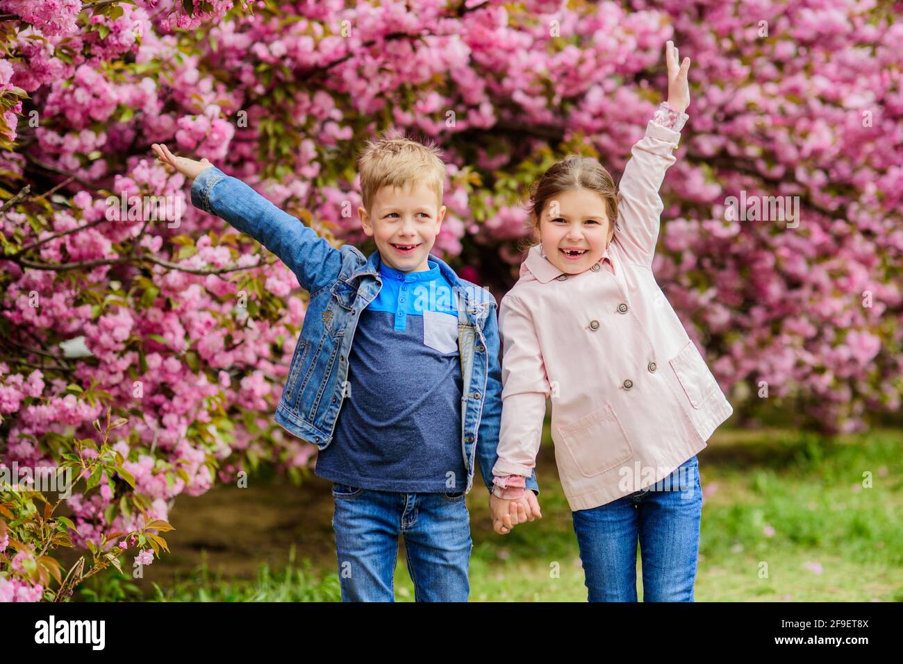 Couple kids walk sakura tree garden. Tender love feelings. Little girl ...