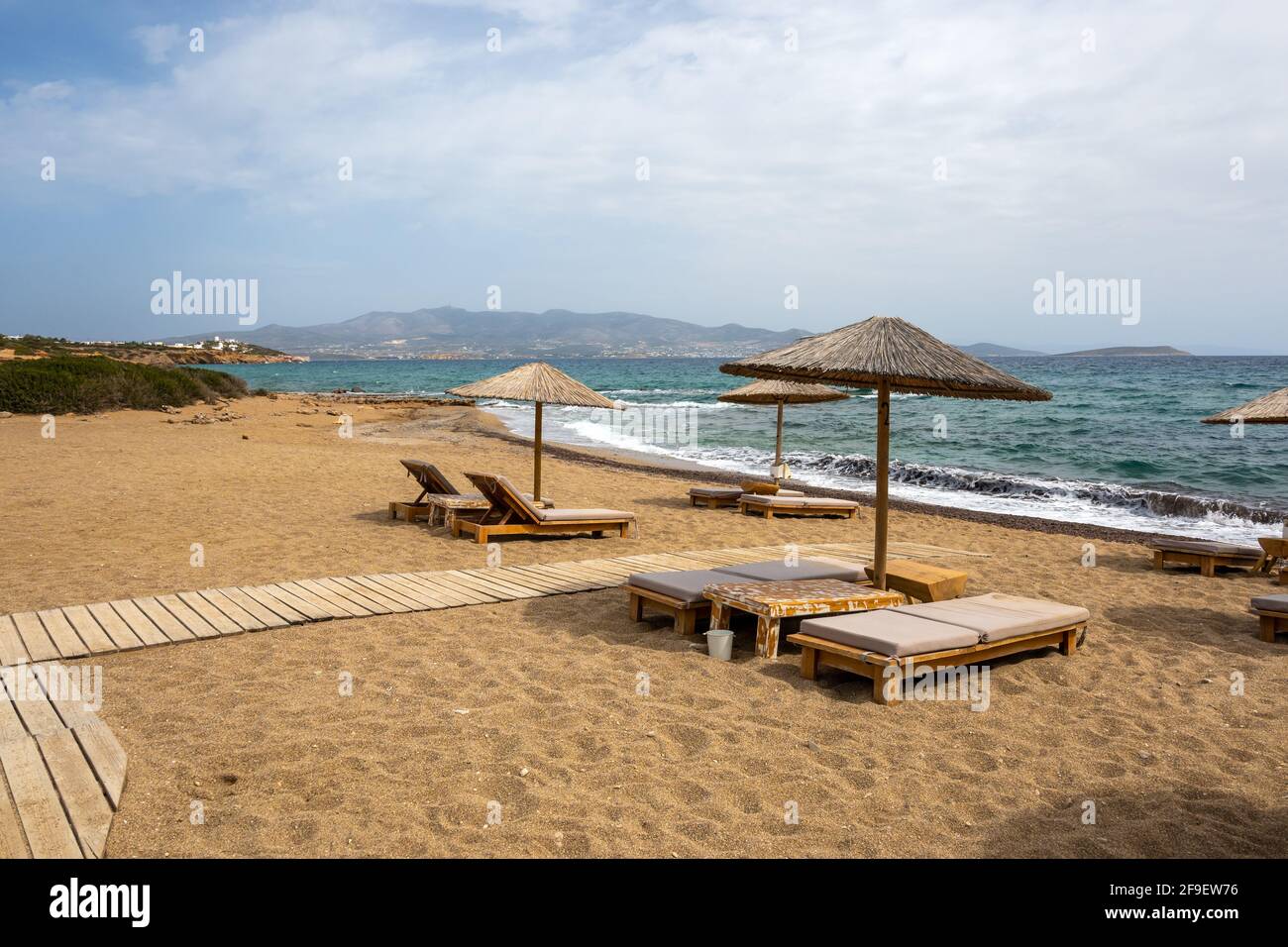Sun beds and umbrellas at Soros beach on Antiparos Island. A wonderful ...