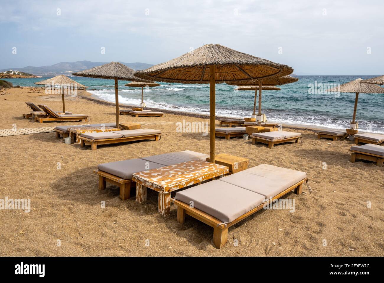 Sun beds and umbrellas at Soros beach on Antiparos Island. A wonderful ...