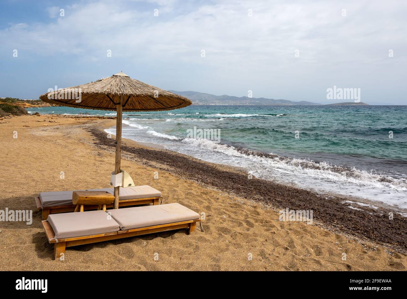 Sun beds and umbrellas at Soros beach on Antiparos Island. A wonderful ...