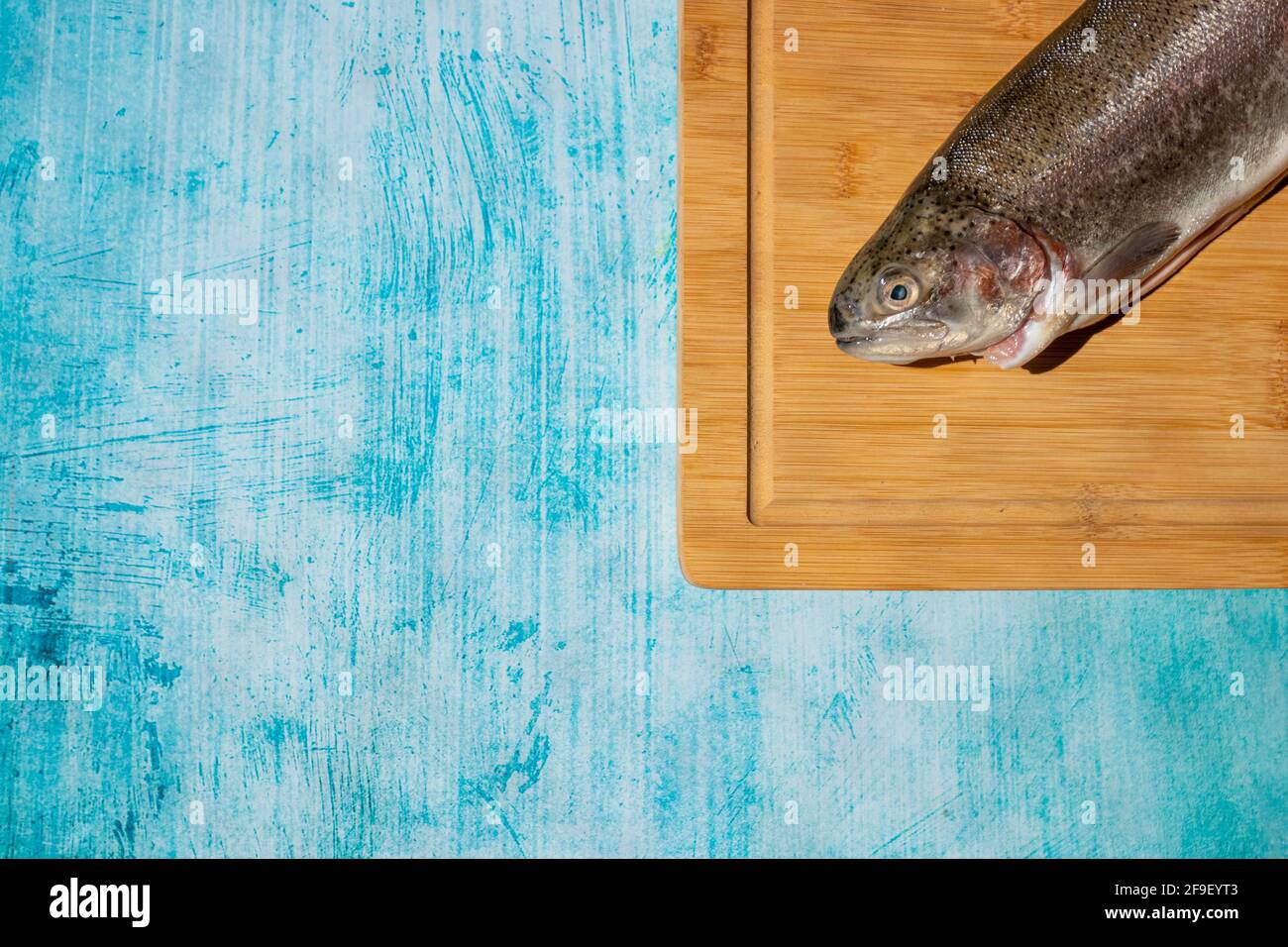 Two fresh fish on kitchen board with blue background Stock Photo - Alamy