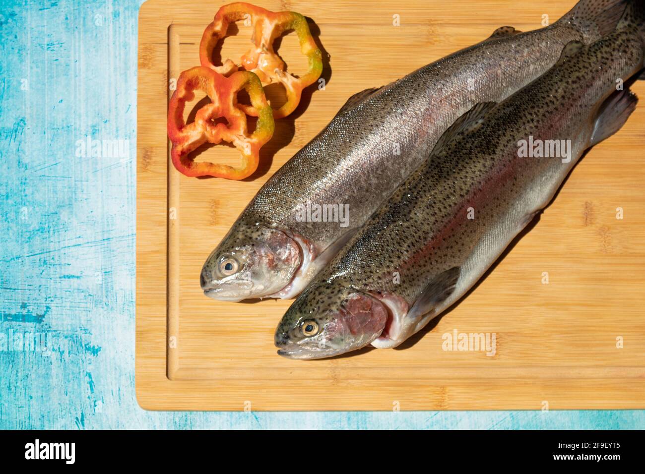 Two fresh fish on kitchen board with blue background Stock Photo - Alamy