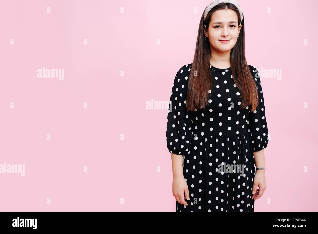 Portrairt of a modest-looking young woman in a polka dot dress over ...
