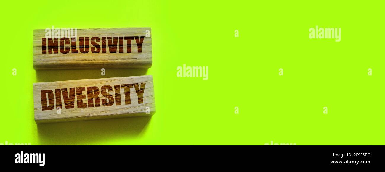 Inclusivity diversity words on wooden block on the yellow background ...