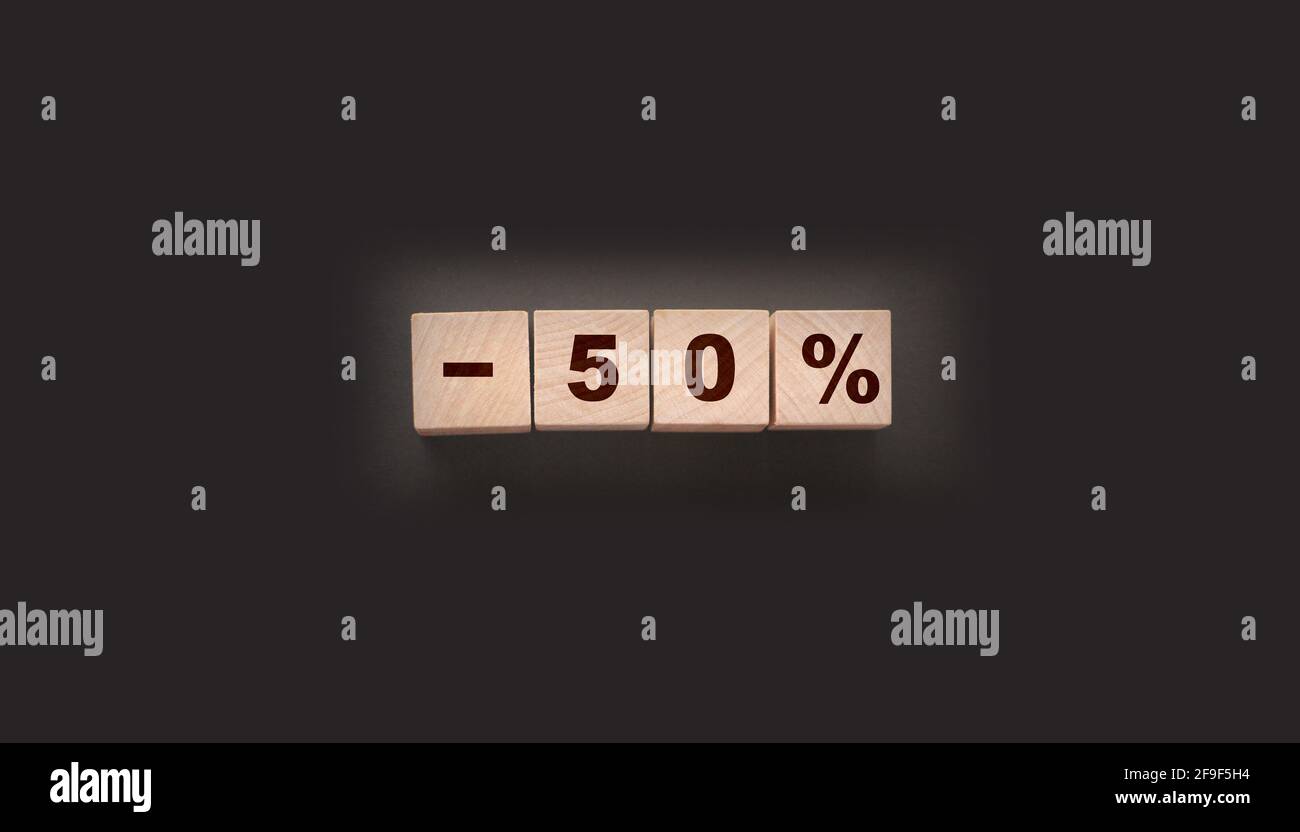 Minus 50 percent phrase on wooden blocks on black background. Sale ...