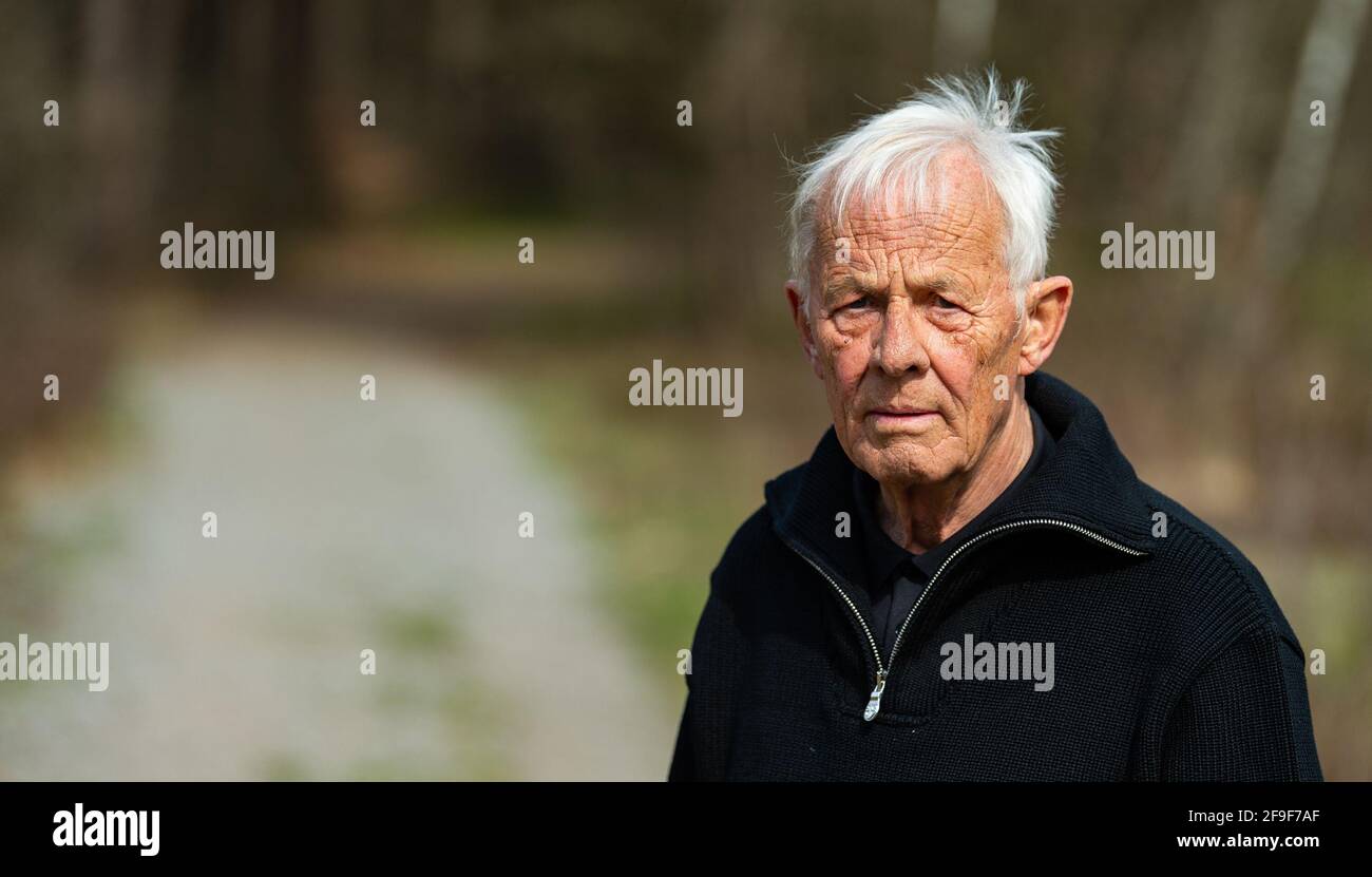 Lohheide, Germany. 18th Apr, 2021. Rolf Becker, actor, stands on a ...