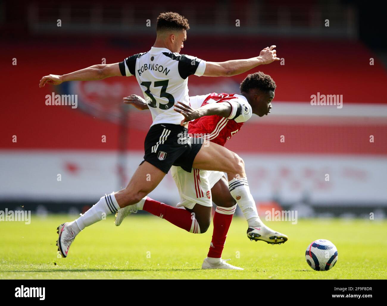 Fulham's Antonee Robinson (left) and Arsenal's Bukayo Saka battle for the ball during the ...