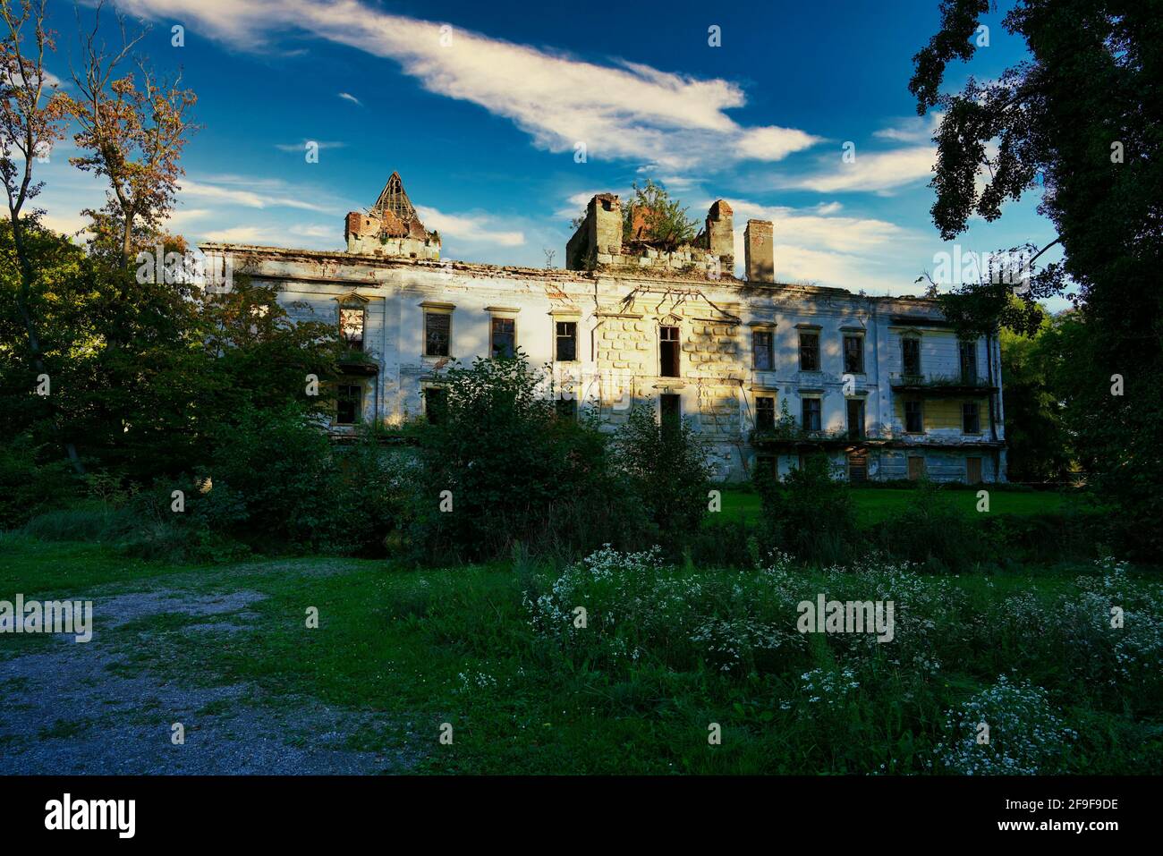 An old building in a state of disrepair under a bright blue sky with ...