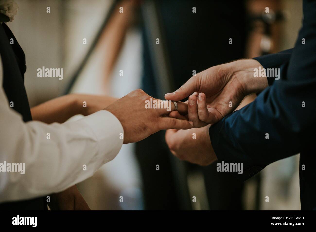A shallow focus of a couple exchanging rings in their wedding ceremony ...