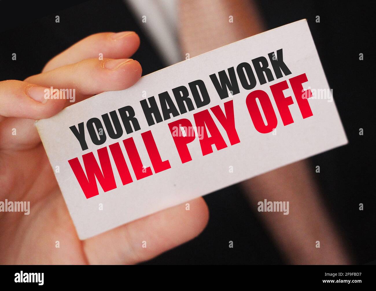 Your Hard Work Will Pay Off inspirational text on card in businessman ...