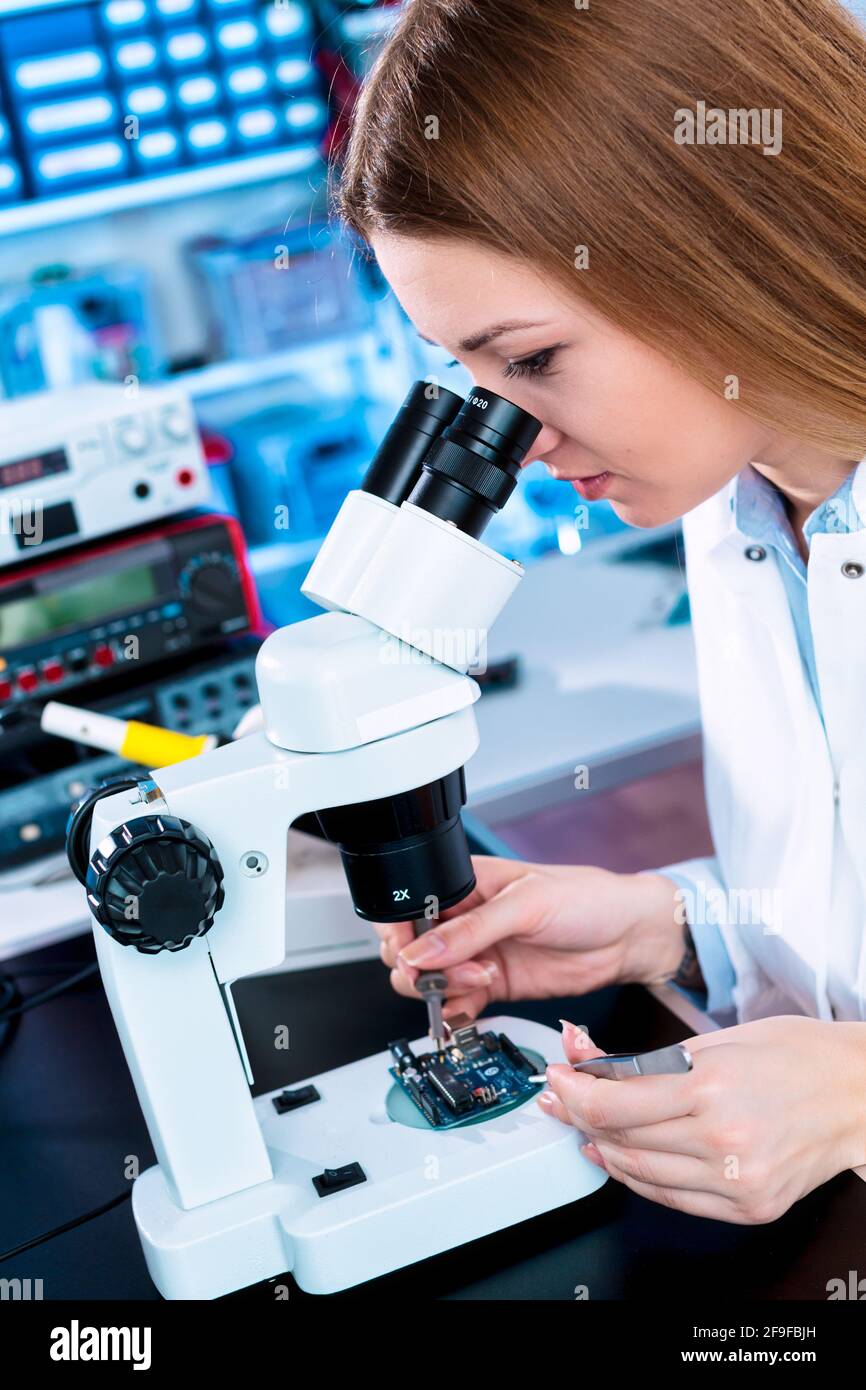 A young woman is testing an electronic module for the production of ...