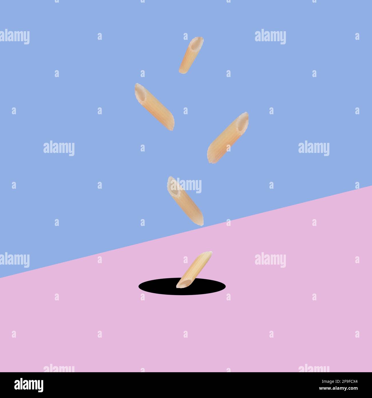 Raw yellow macaroni pasta falling down on pastel blue and pink backdrop ...