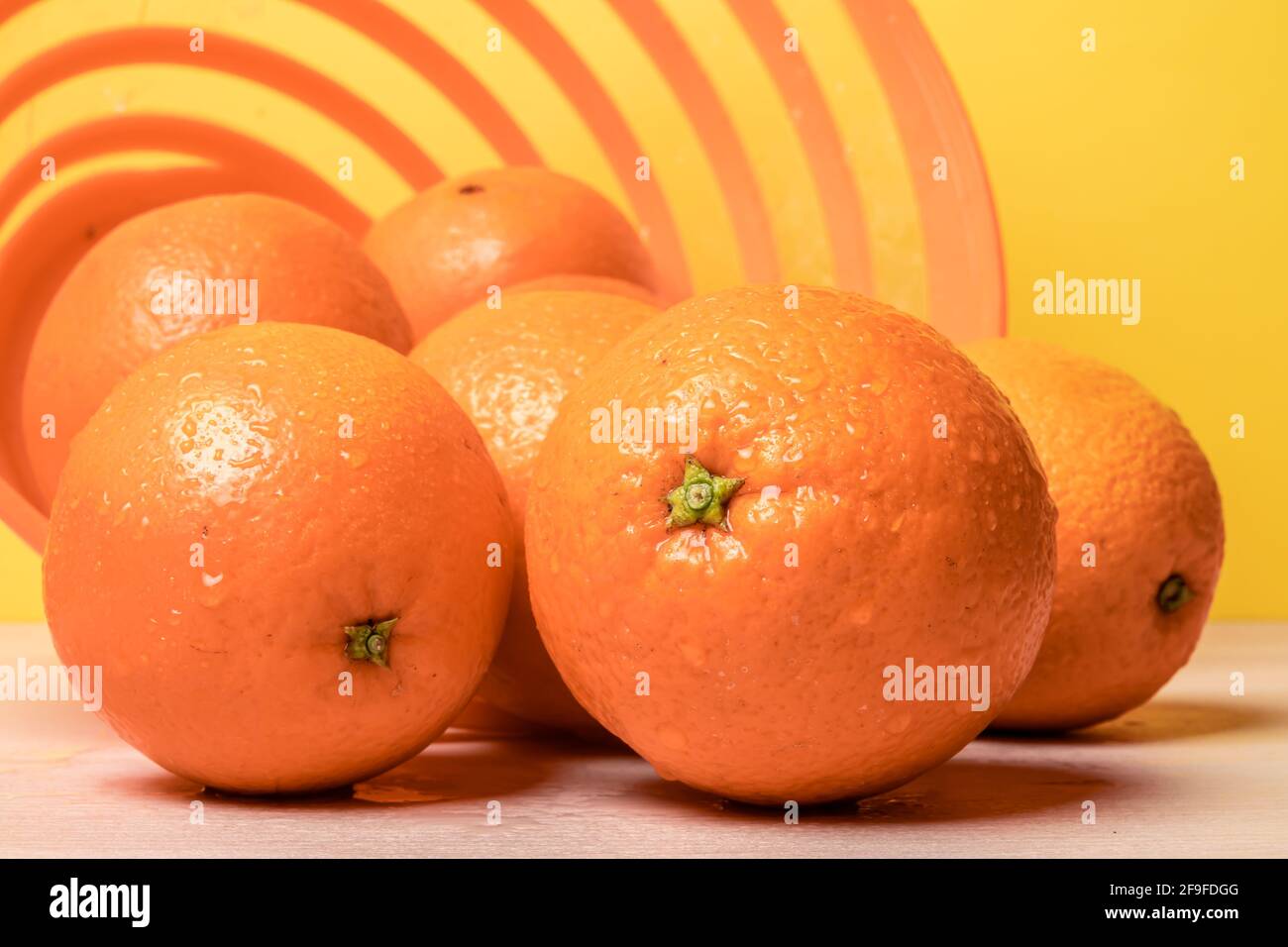 A closeup shot of fresh oranges falling out of a bowl Stock Photo - Alamy