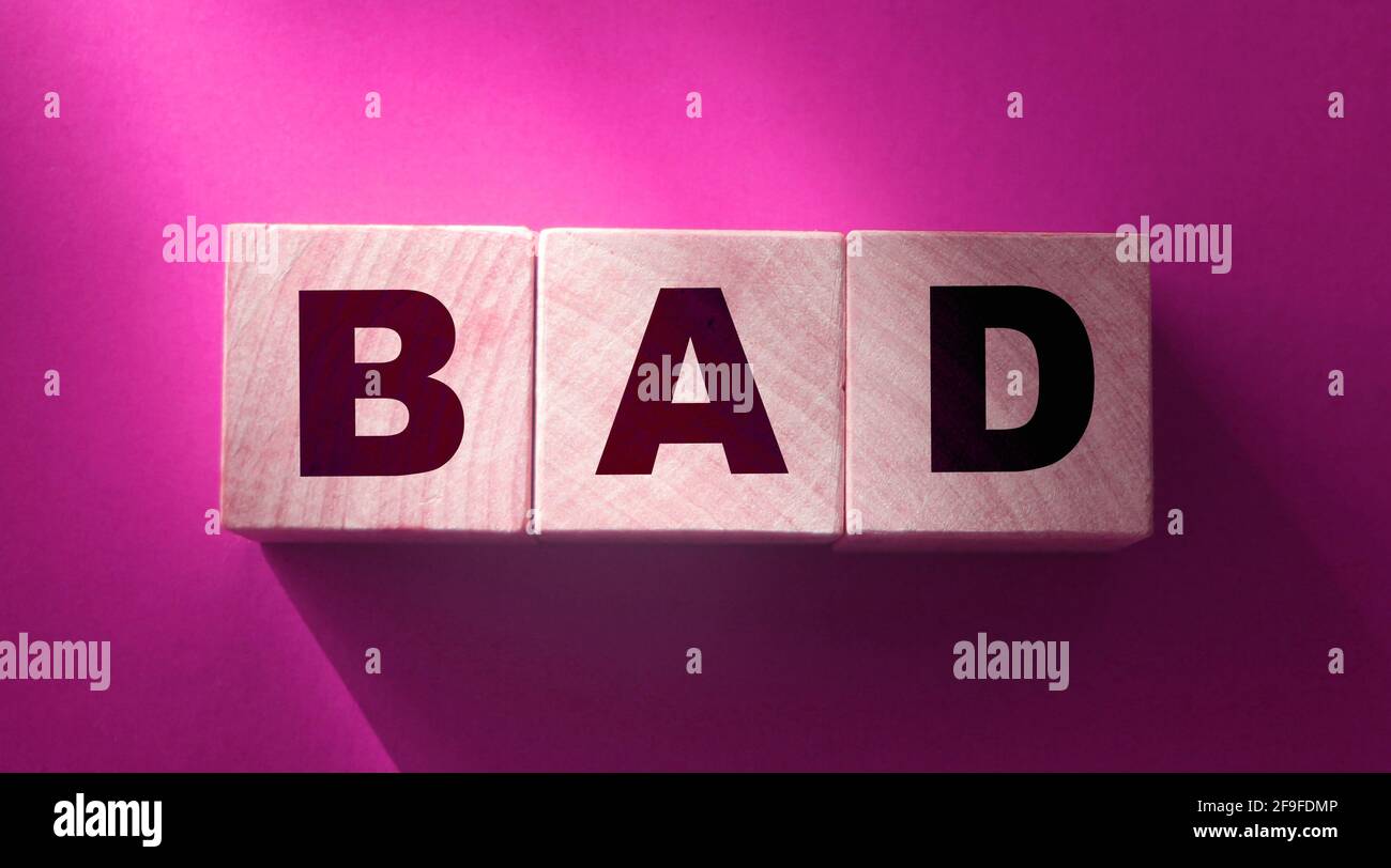 Bad word on wooden blocks on red background. Something negative concept ...