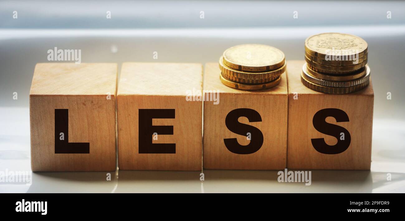 Less word on wooden alphabet blocks and stack of coins. Less spend ...