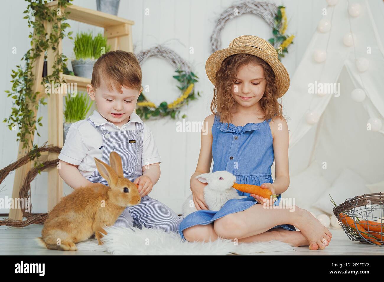 Happy laughing little girl and boy playing with a baby rabbit, f Stock ...