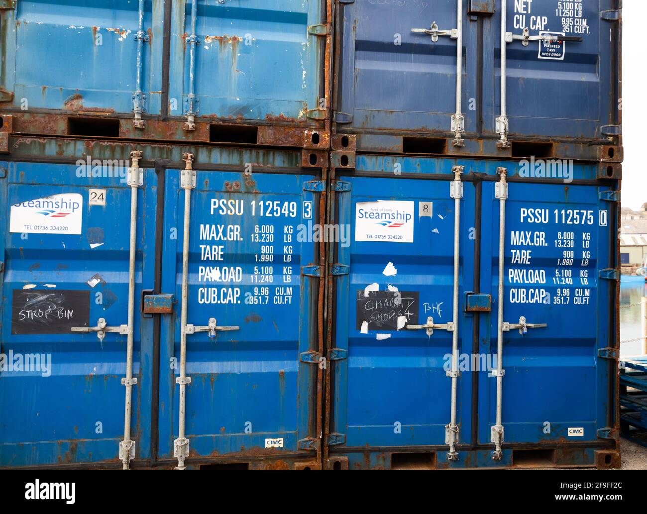 Four metal shipping containers stacked up in Penzance Harbour, Cornwall ...