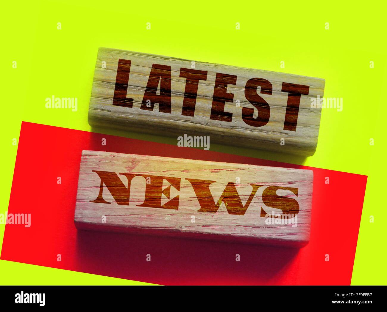 Latest News words on a wooden blocks on yellow and magenta background ...