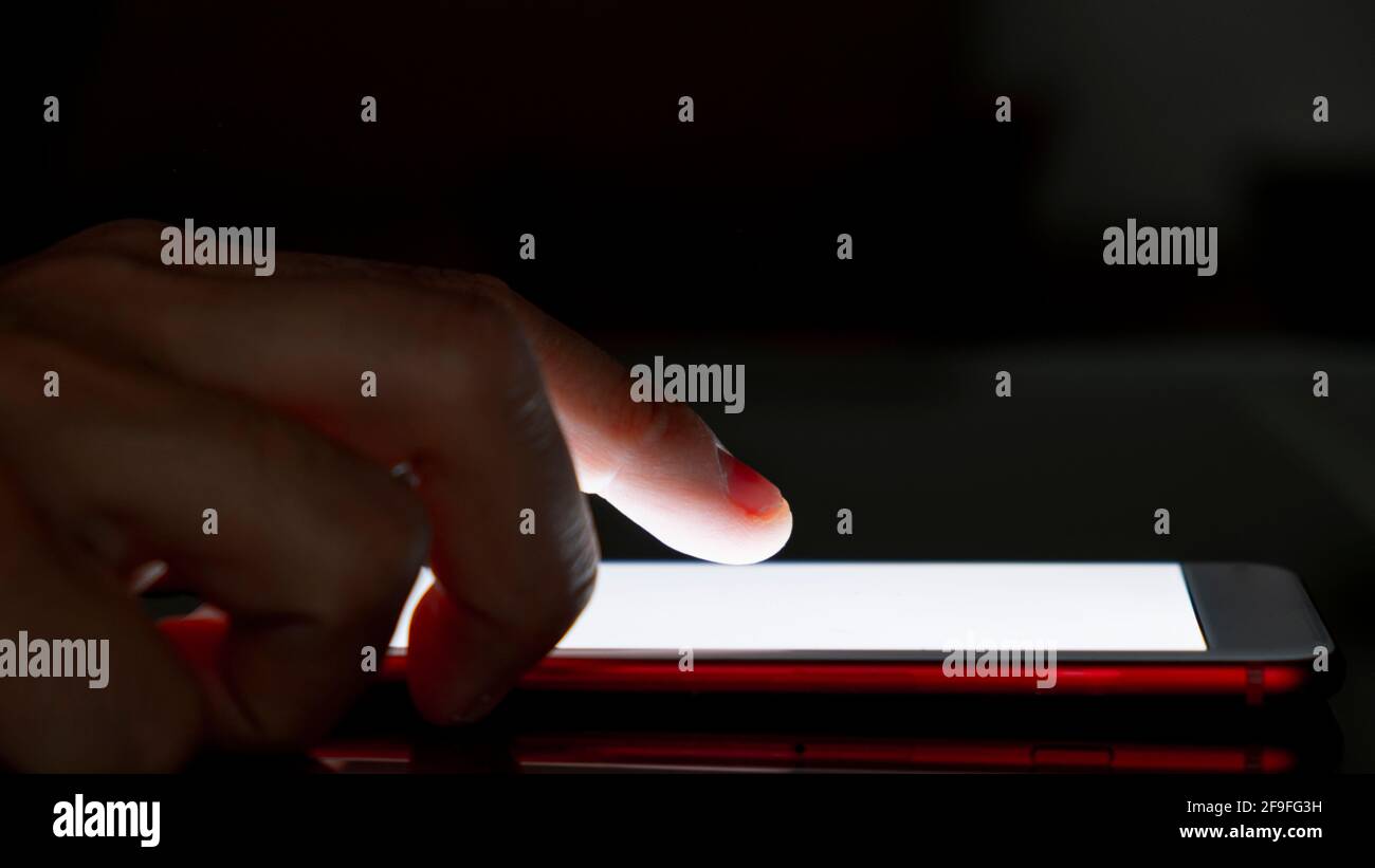 Close-up of a man using his smartphone at night. Insomnia concept. Use ...
