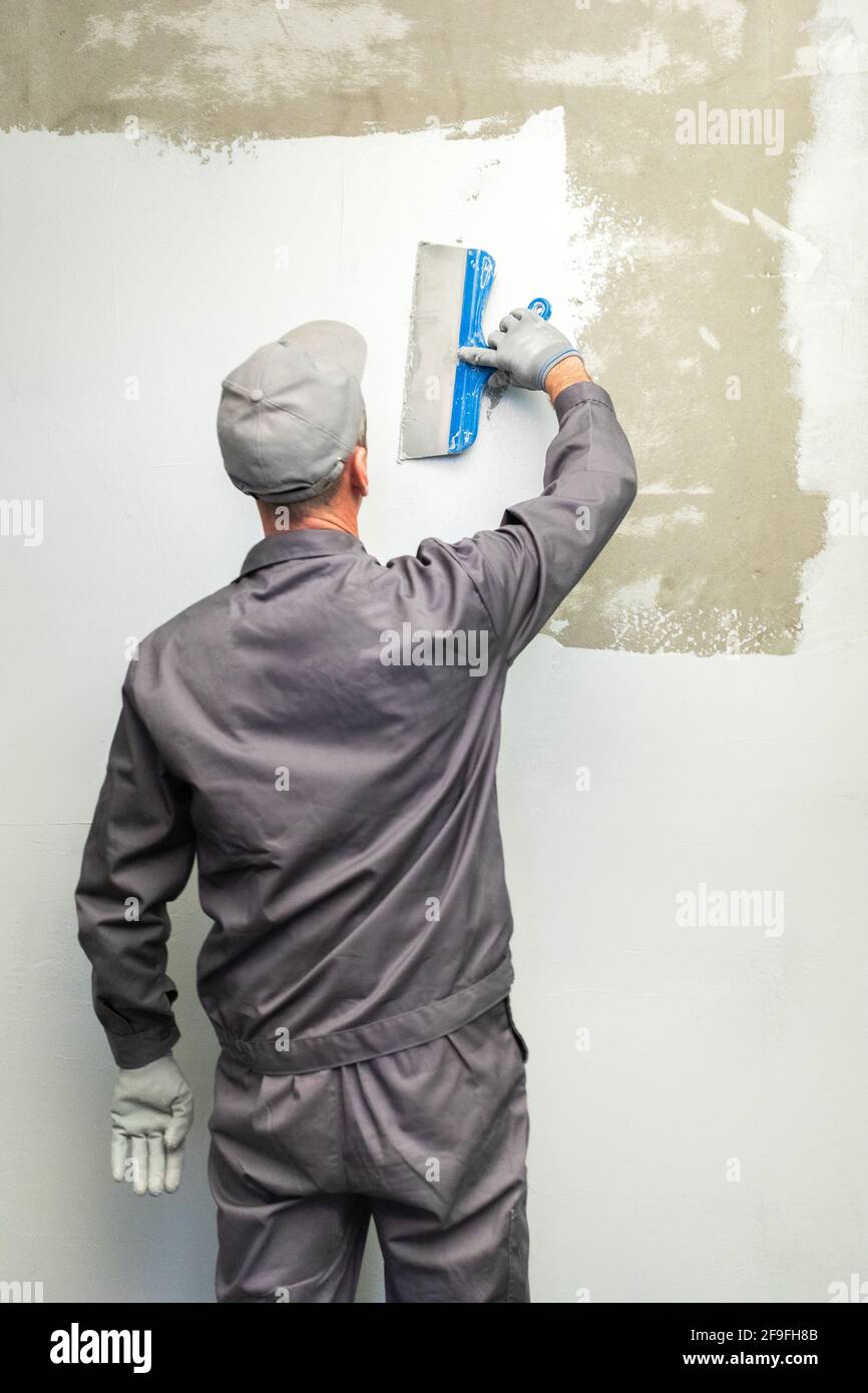 Applying waterproofing mastic to the wall with a wide spatula Stock ...