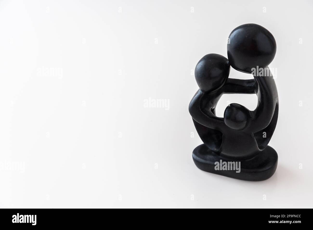 African black wooden figure of a family hugging each other. Isolated on ...