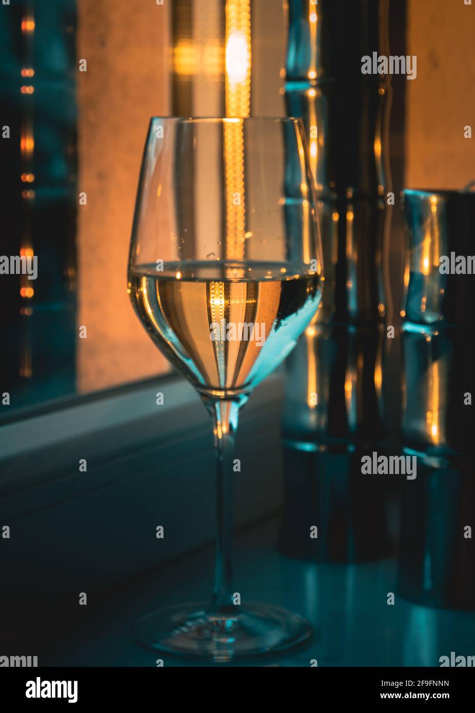 Glass of wine in front of a window and decoration with beautiful sunset ...