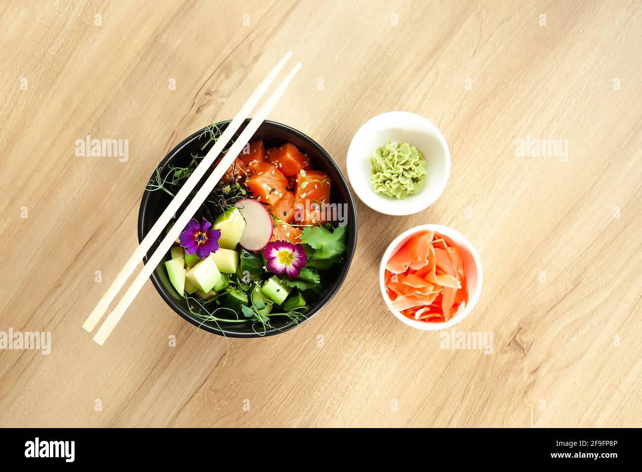 Poke salad with salmon in a bowl next to wasabi and ginger. Ingredients ...
