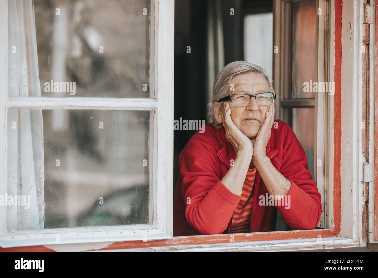 Portrait of lovely senior woman or grandmother watching out from the ...