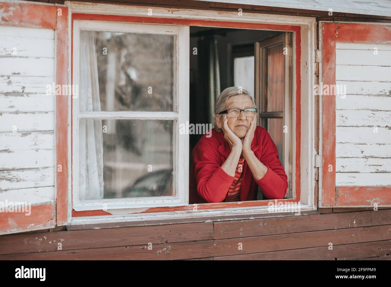 Portrait of lovely senior woman or grandmother watching out from the ...