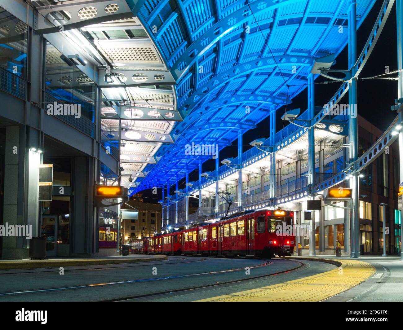 Red train at a station at night with curve in the rails Stock Photo - Alamy