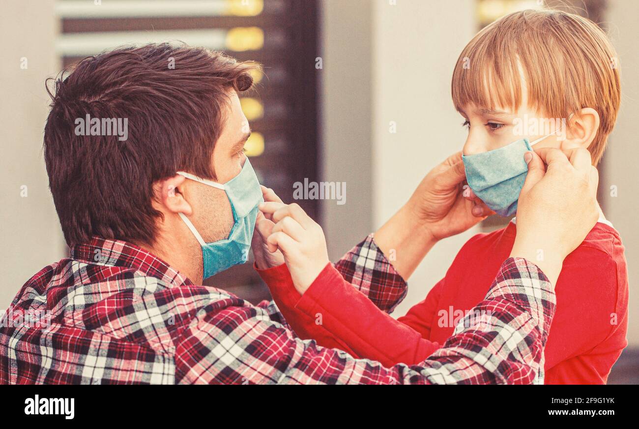 Father puts a medical mask on her son. Coronavirus, illness, infection ...