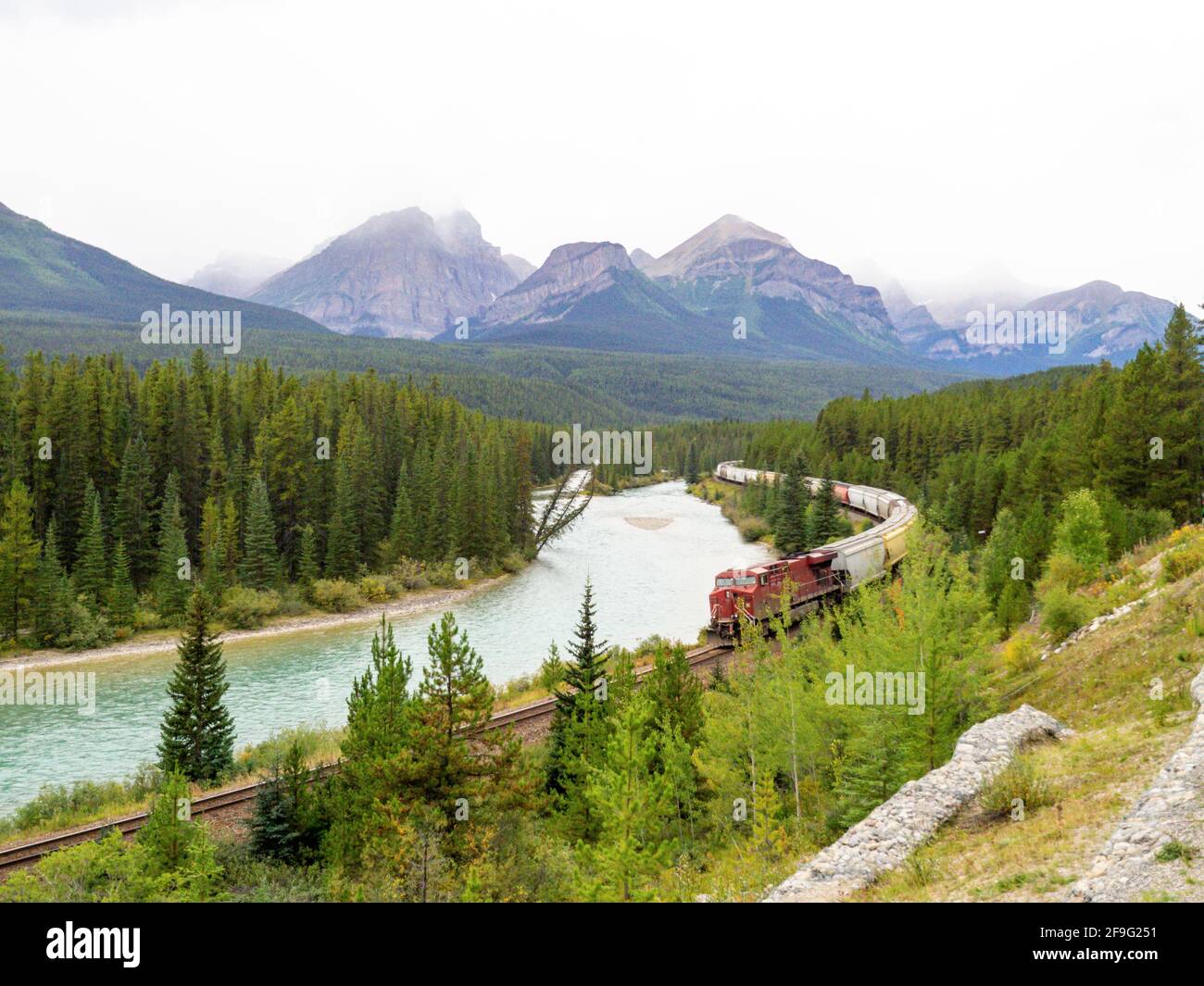 red train traveling on a curved railroad Stock Photo - Alamy