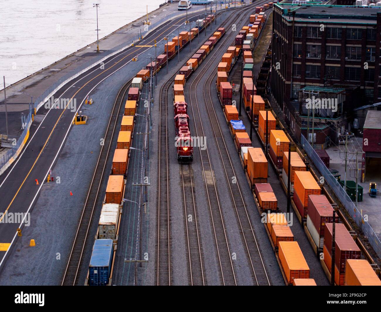 view of a freight train with a red locomotive in between two other ...