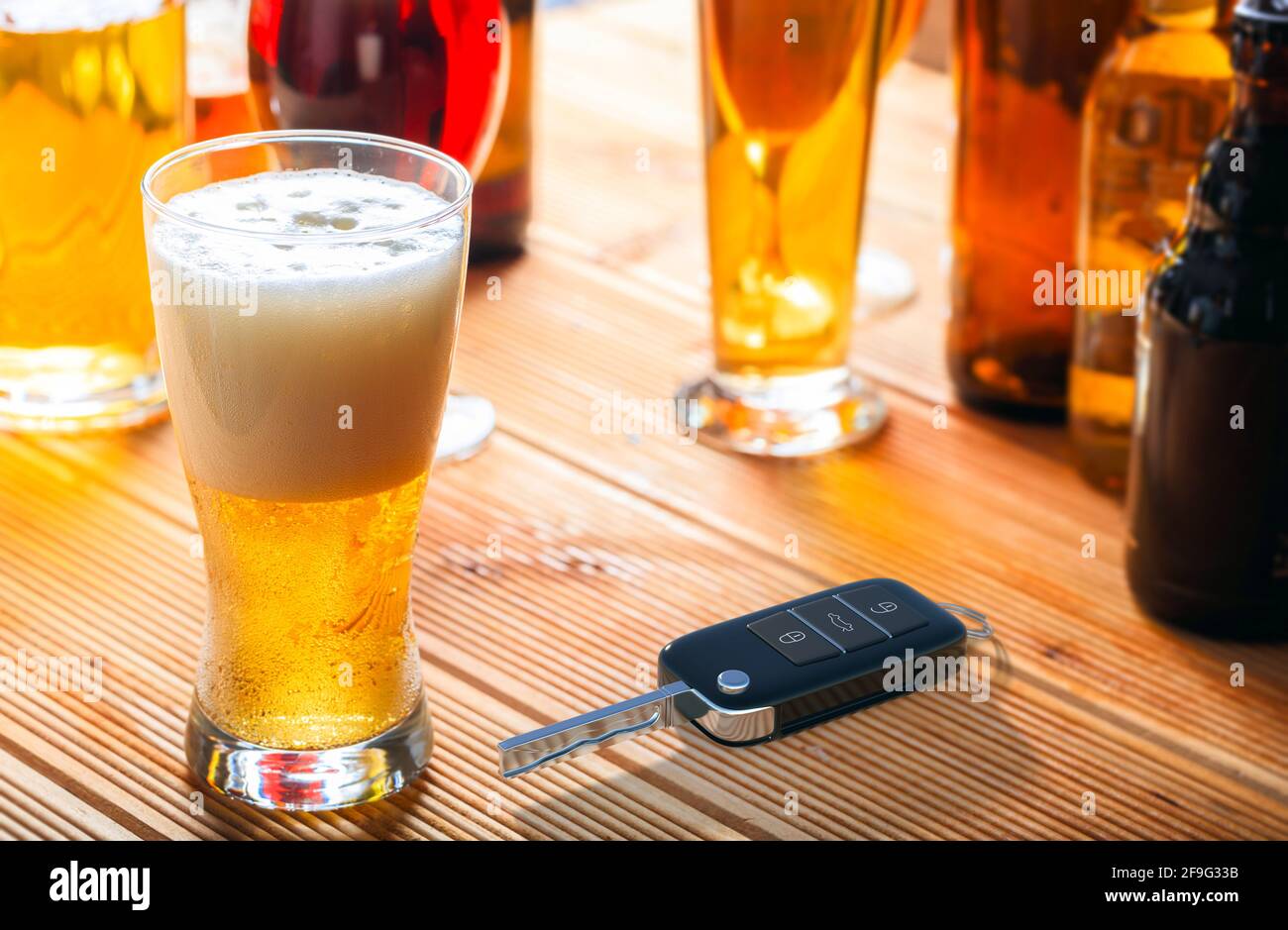 Drinking and driving concept. Car key and beer glass on a wooden pub ...
