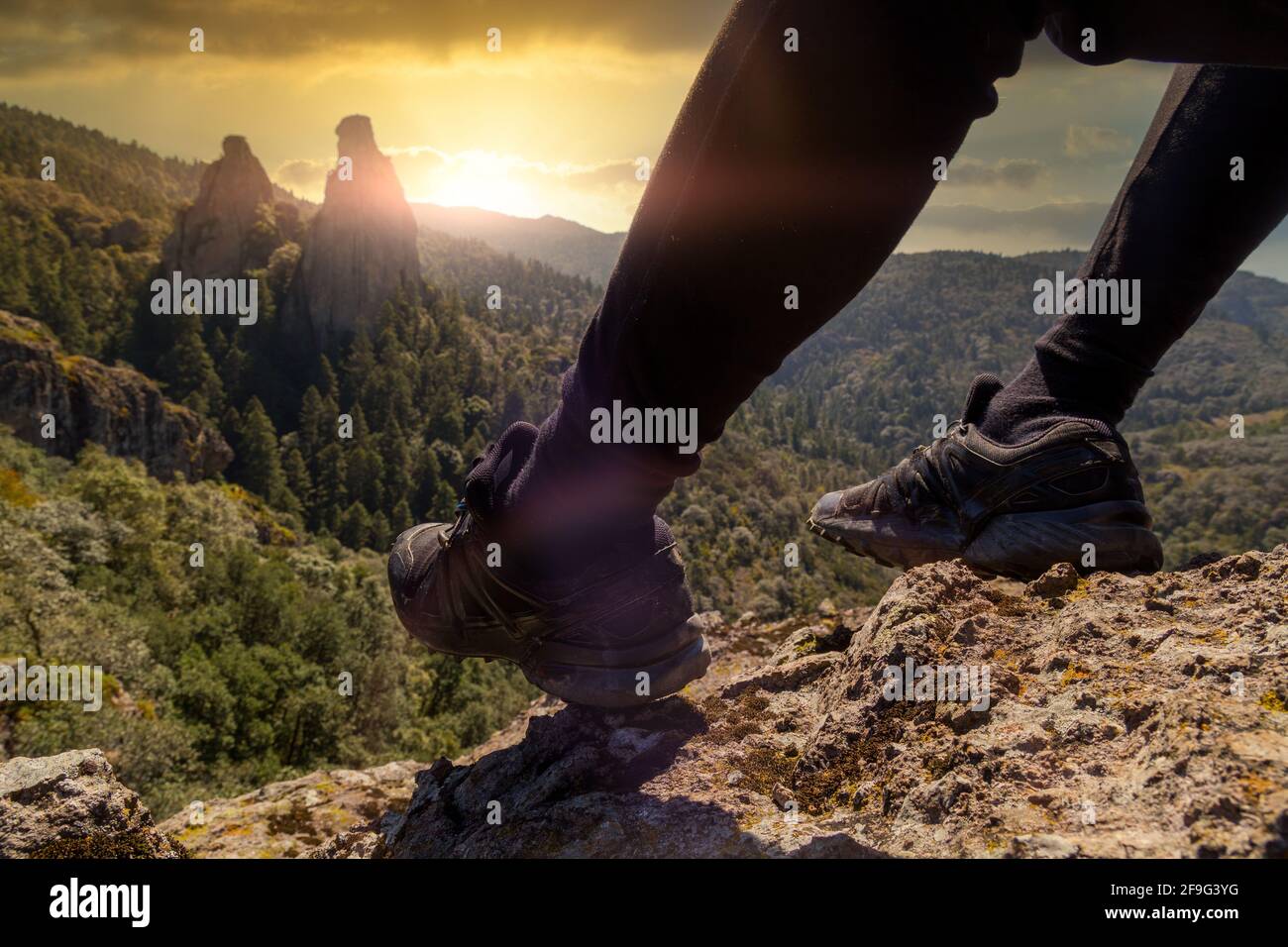 A closeup shot of a rock climber sitting on a peak of a mountain and ...
