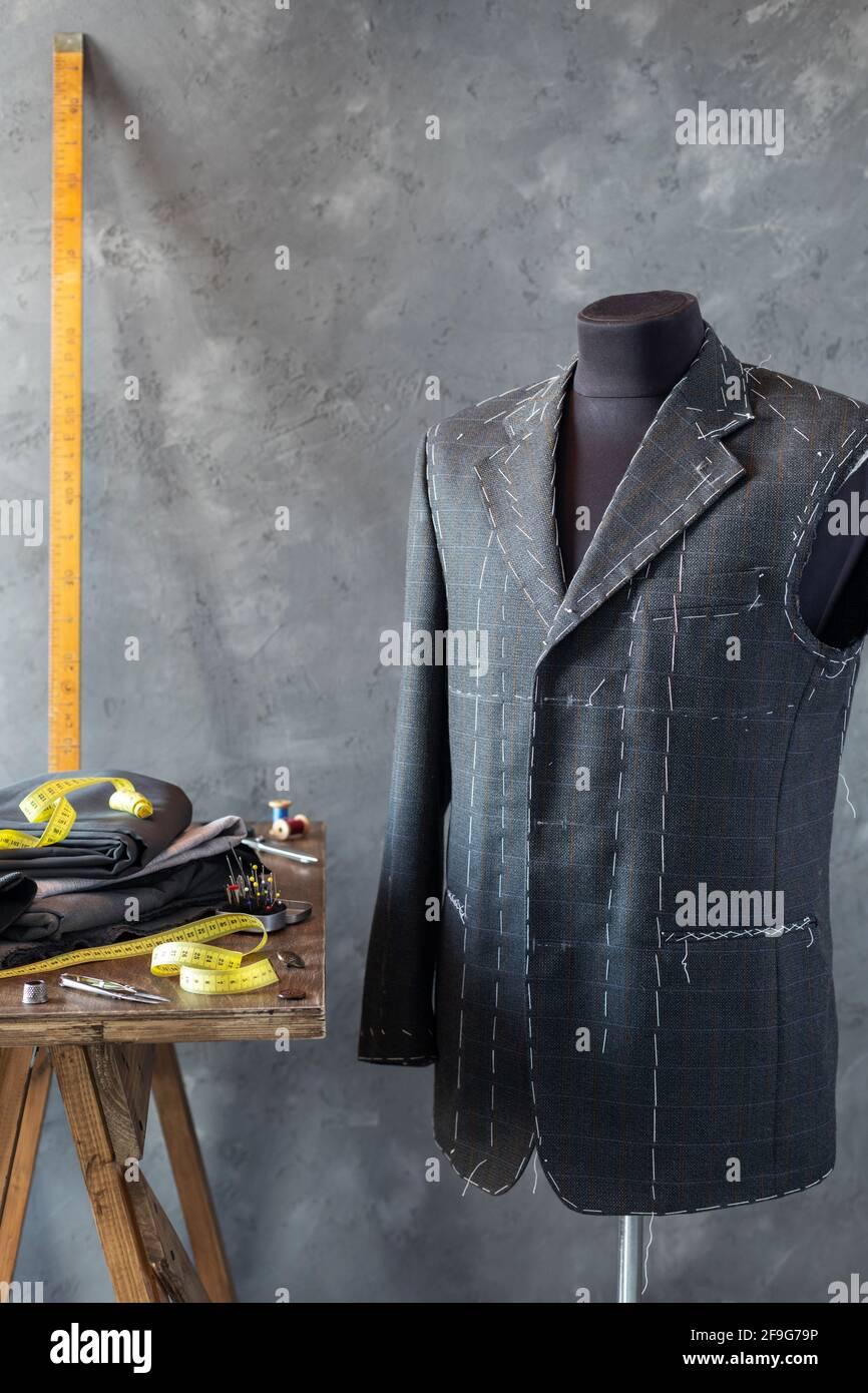 suit jacket on male tailor mannequin and sewing tools, creative concept ...