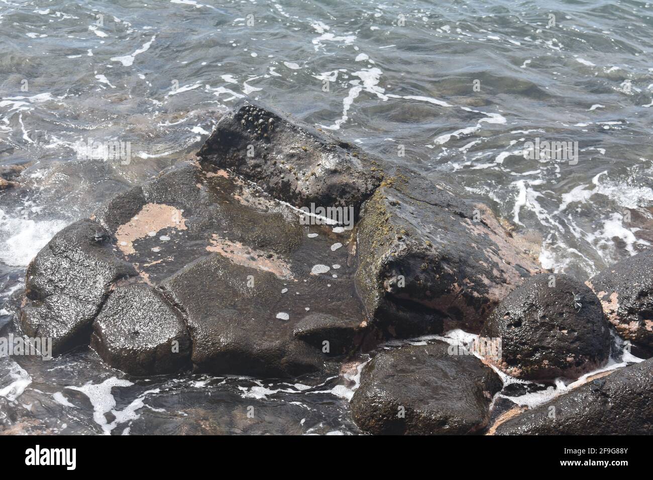 The black volcanic rock from the Pacific Ocean on the coast of the ...