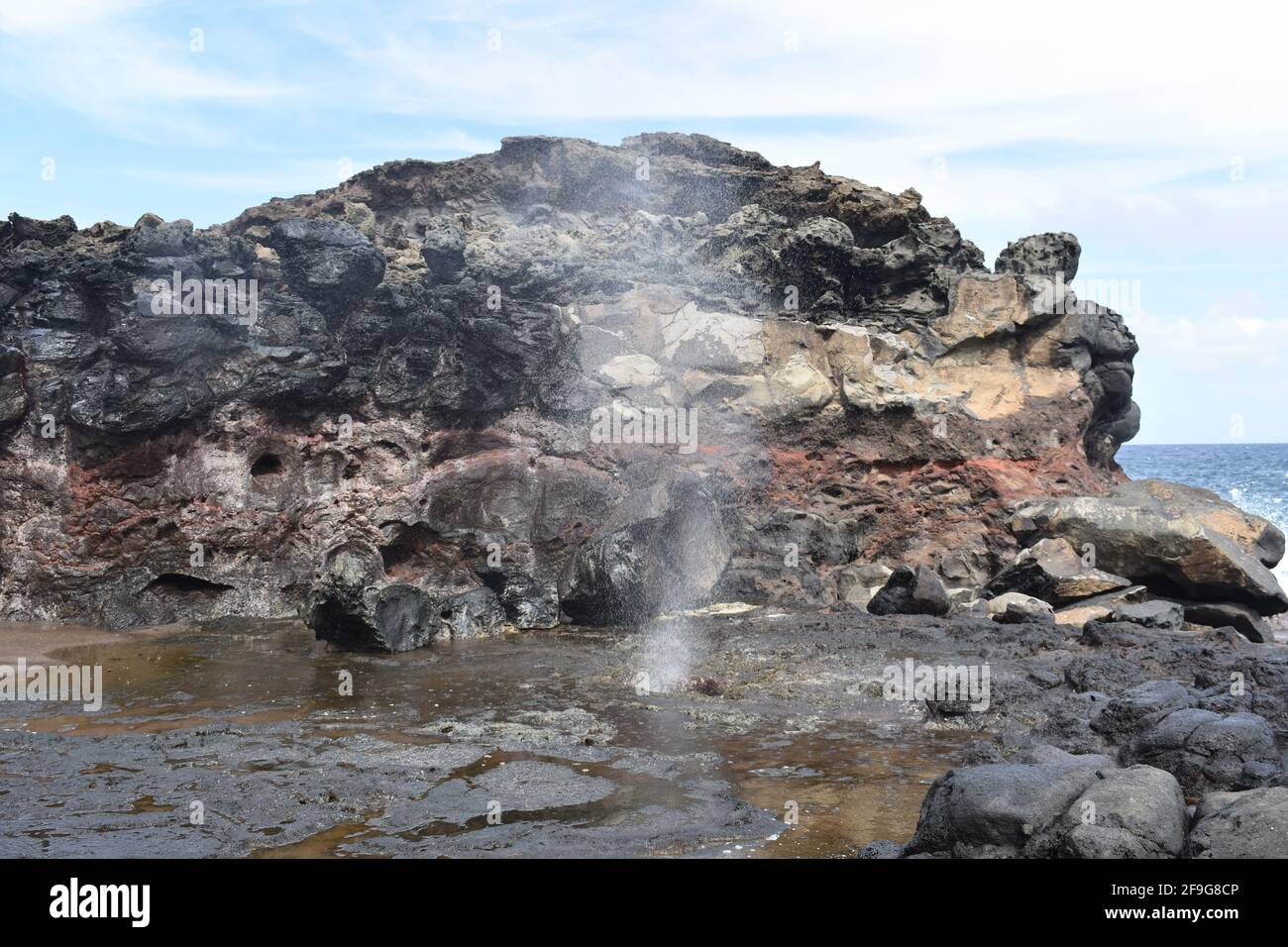 The Nakalele Blowhole emerging from the natural volcanic rock landscape ...