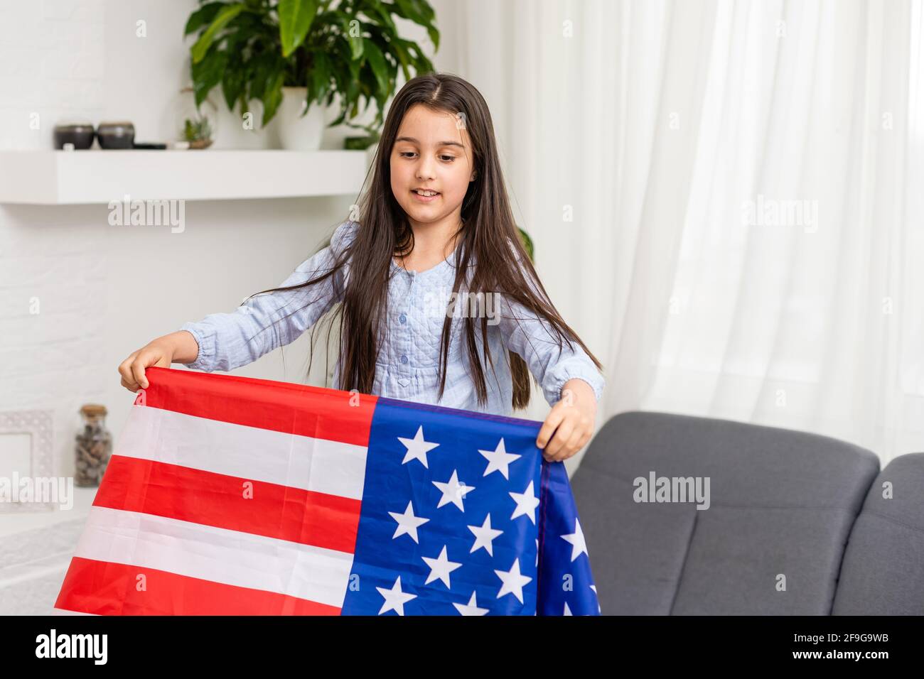 Cute little girl and USA flag on background Stock Photo - Alamy